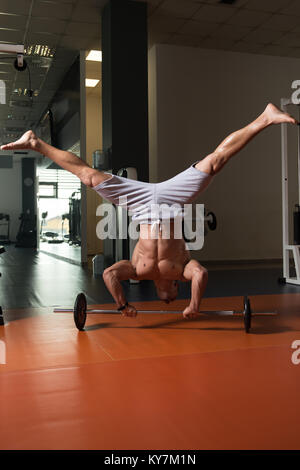 Bodybuilder Doing Handstand Push Ups On Barbell As Part Of Bodybuilding ...