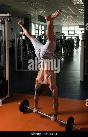 Bodybuilder Doing Handstand Push Ups On Barbell As Part Of Bodybuilding ...