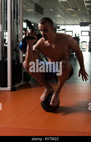Athlete Doing Kettle Bell Exercise On Medicine Ball As Part Of ...