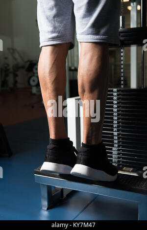 Close-up of bodybuilders muscular legs. Athlete man doing workout ...