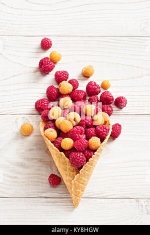 Raspberry explosion. Photo of raspberry in waffle cone on black slate ...