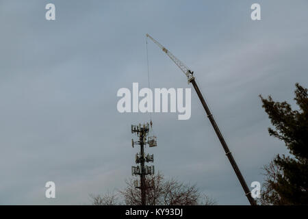 Telecom tower climber working on top of radio tower installing a ...