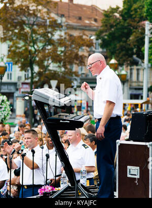 Classical music event. Bald man in formal wear playing violin against ...