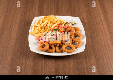 Squid rings with potatoes and fresh vegetables and herbs served at ...