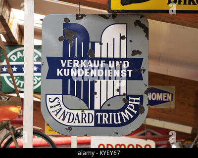 A vintage enamel advertising sign for Standard Triumph, promoting their ...
