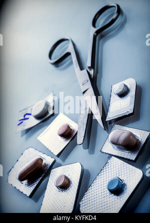Scissors next to several blister cut, conceptual image Stock Photo - Alamy