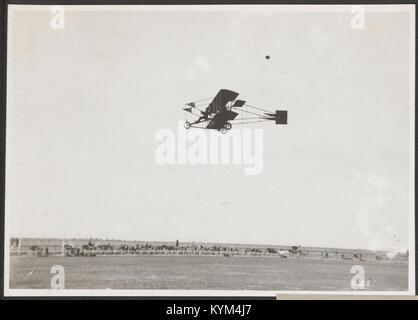 A historic photograph of a Curtiss Pusher biplane in flight at dusk ...