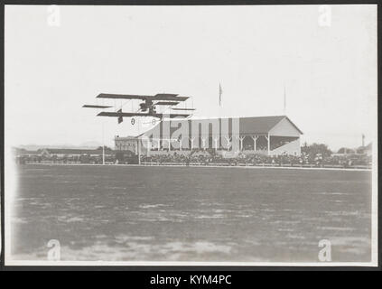 A historic photograph of a Curtiss Pusher biplane in flight at dusk ...