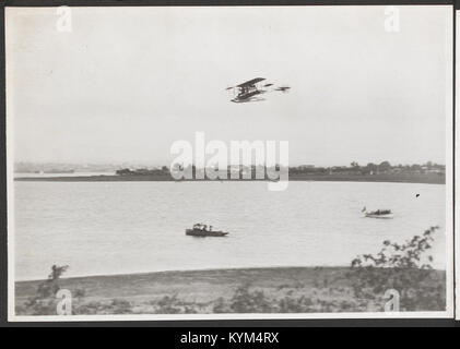 A Curtiss Pusher aircraft flying over a crowd of onlookers, showcasing ...