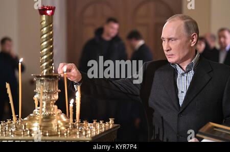 Russian President Vladimir Putin lights a candle during a visit to the ...