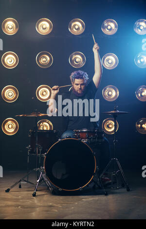 Bearded drummer with colorful hair on the stage with lights, vintage ...