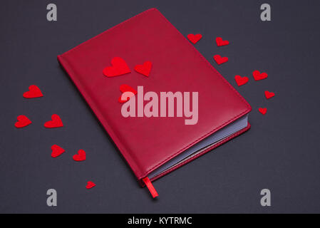Diary with red hearts on a dark background Stock Photo - Alamy