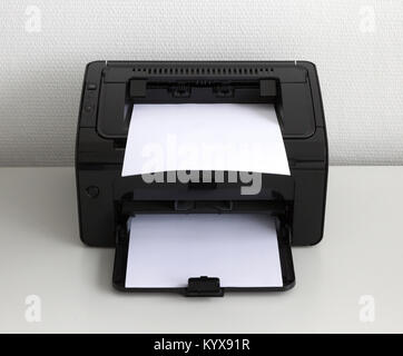 Home laser printer on desk against green background Stock Photo - Alamy