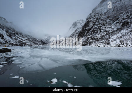 Reflection of mountain with ice floe floating on water, Lofoten ...