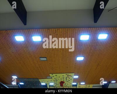 Luminous ceiling of square tiles. Wooden ceiling with lighting panels ...