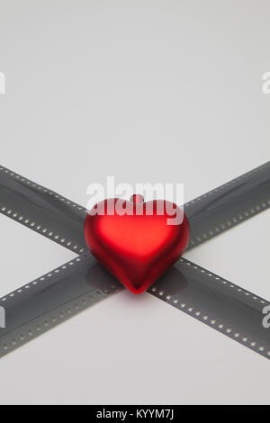 The red heart and the unrolled exposed 35mm film strips over a white ...