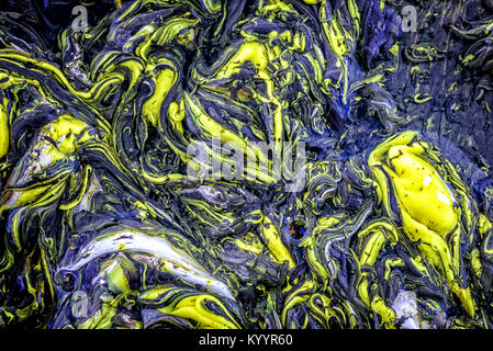 Congealed oil on water in yellow and black creating an abstract organic ...