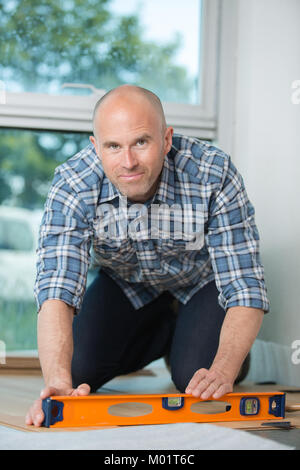 craftsman measuring a plank of wood with a spirit level Stock Photo - Alamy