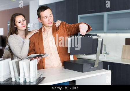 angry couple makes claims at kitchen furniture workshop Stock Photo - Alamy