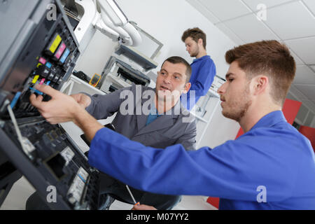 an apprentice fixing a printer Stock Photo - Alamy