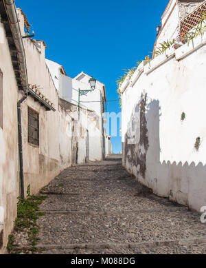 Street alley with white walls and a moorish arch inside the Marrakech ...