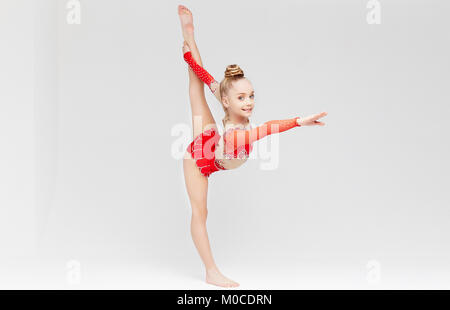 Little female professional gymnast doing split, standing on arms on ...