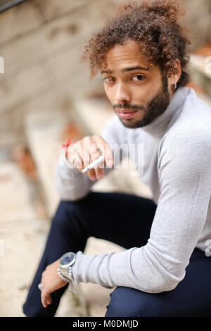Sad mix blood man smoking on steps Stock Photo - Alamy