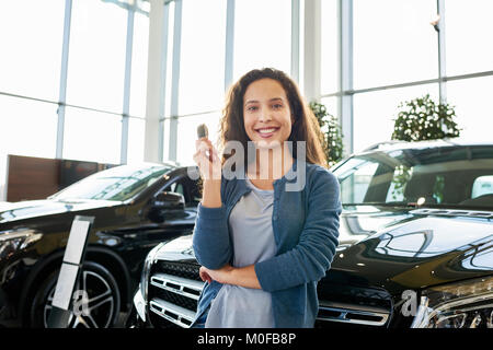 Happy owner of a new car. Pretty woman driver smiling to you from her ...