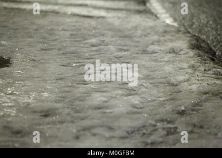slippery ice and compacted snow covered path under streetlights at ...