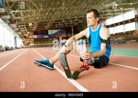 Sprinter sitting with prosthetic leg on Stock Photo - Alamy