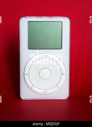 an original apple ipod with earbud headphones photographed on a white ...
