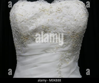 White wedding dress embroidered with beads hanging on chandelier Stock ...