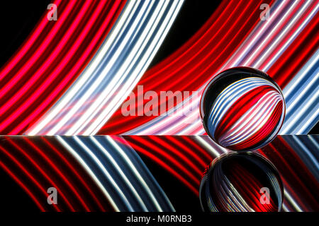 glass/crystal ball reflecting light streaks of color red, white, blue ...
