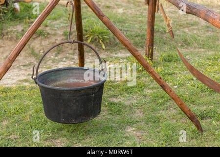 Beautifull Ancient copper pot tied to logs to cook food Stock Photo - Alamy