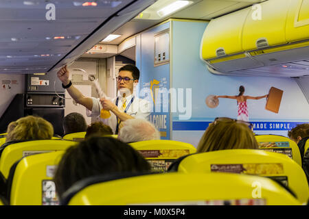 Cabin crew holding up the oxygen mask during the safety demonstration ...