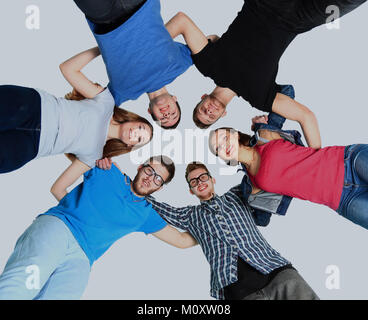 portrait of confident college students forming huddle over white ...