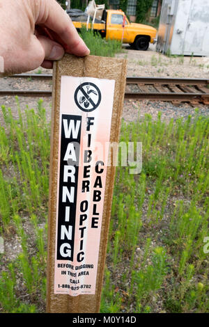 Sign warning that fiber optic cable is buried below Stock Photo - Alamy