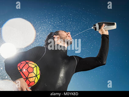 Hispanic man with beard holding soccer ball angry and mad screaming ...