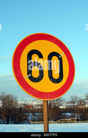 Speed limit at 60 kmph traffic sign by the road, blurred car in motion ...