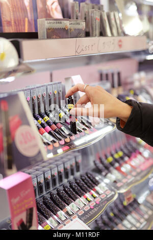 Young female customer testing lip gloss in store Stock Photo - Alamy