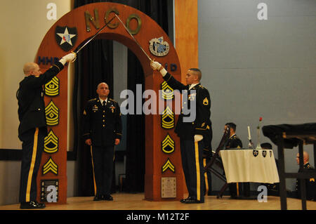 A newly promoted NCO walks through the NCO arch and crossed sabers ...