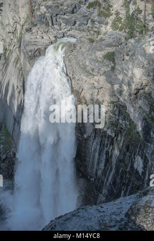 Looking down over waterfall going into deep gorge surrounded by green ...