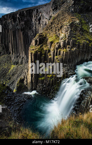 Litlanesfoss waterfall and river flowing between basalt columns on an ...