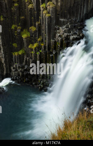 Litlanesfoss waterfall and river flowing between basalt columns on an ...