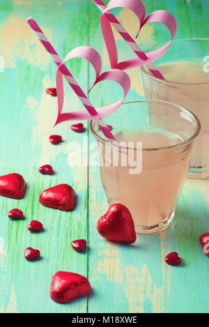 Ruby red grapefruit juice and heart shape chocolates over wooden ...