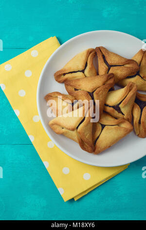 Plate with tasty hamantaschen for Purim holiday on color background ...