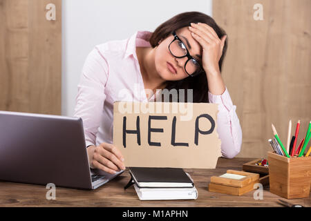 Sad businesswoman holding a help sign Stock Photo - Alamy