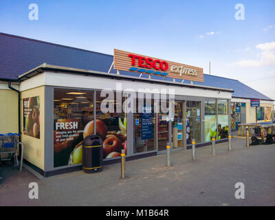 Tesco Express store, shop front exterior entrance, at dusk at Greenwich ...