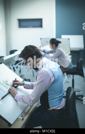 Executive working on blueprint Stock Photo - Alamy
