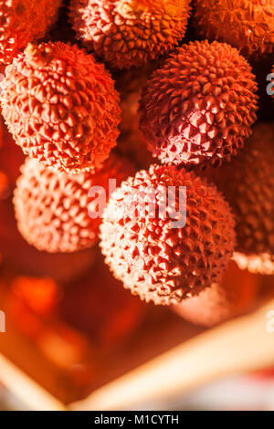 Still life of ripe exotic lychee fruits in rustic brown bowl. Red ...